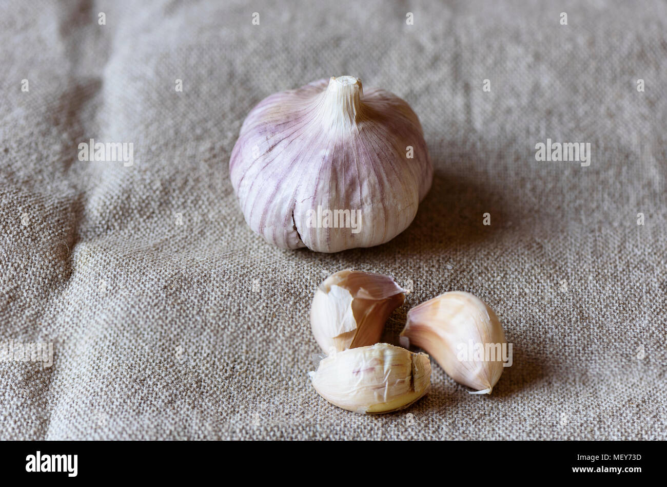 Garlic and garlic cloves on bagging background Stock Photo - Alamy