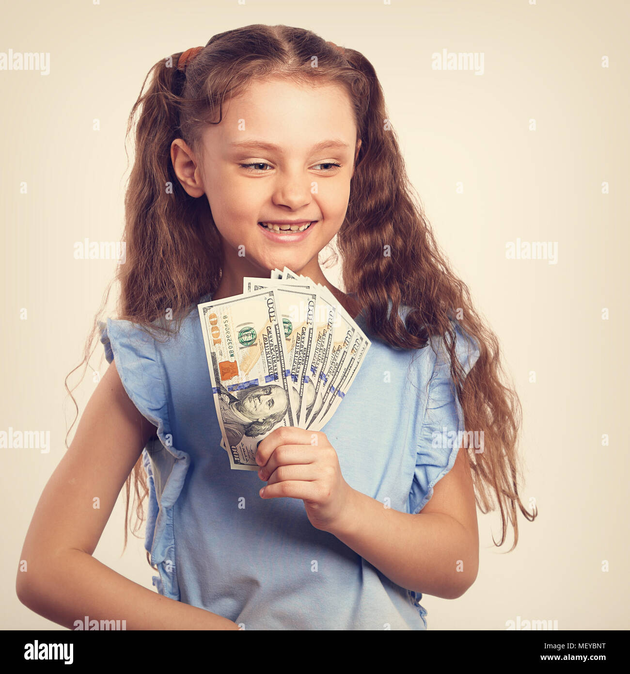 Happy smiling rich kid girl holding money in the hand with natural ...
