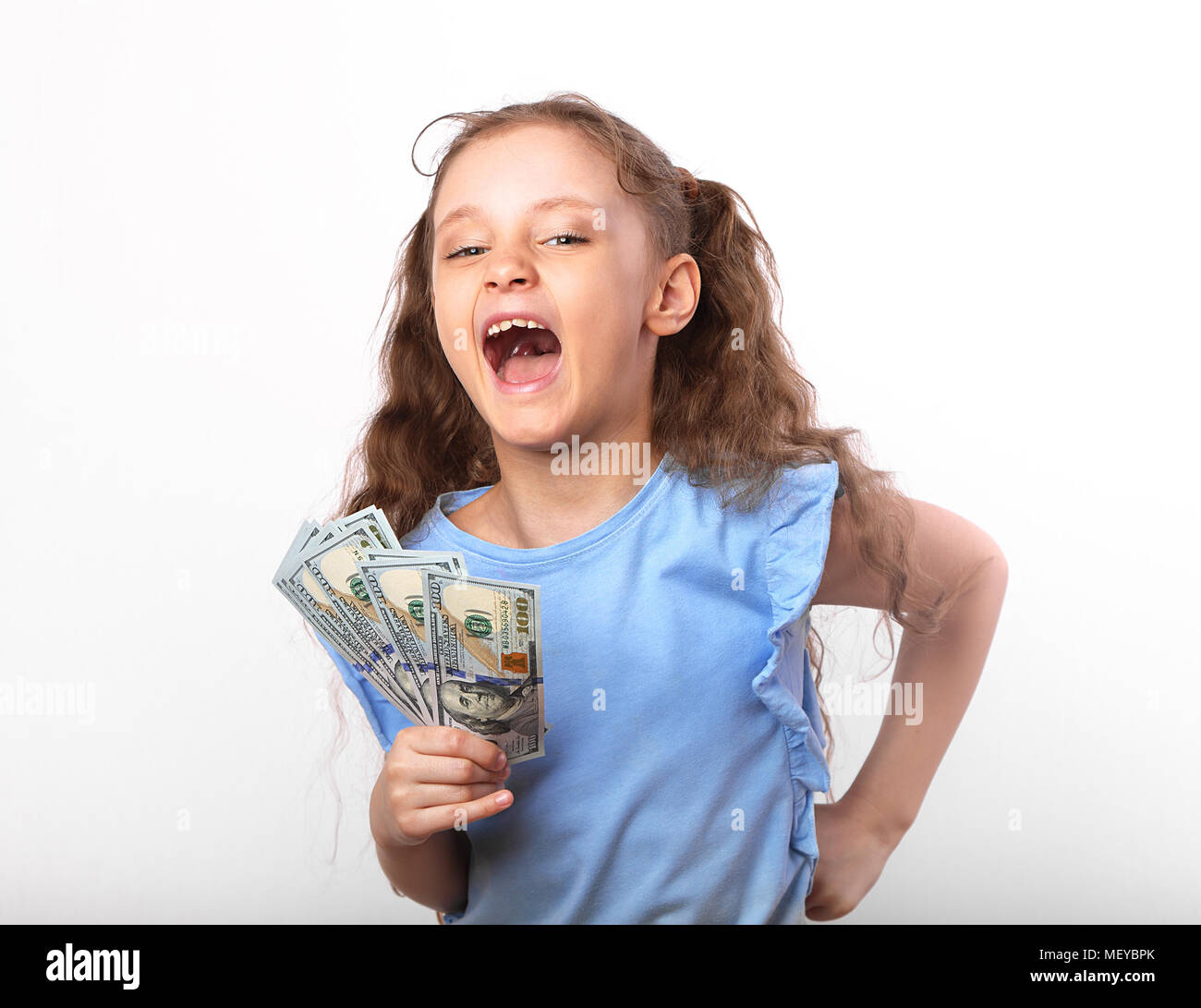 Happy laughing rich kid girl holding money the hand on empty copy space ...