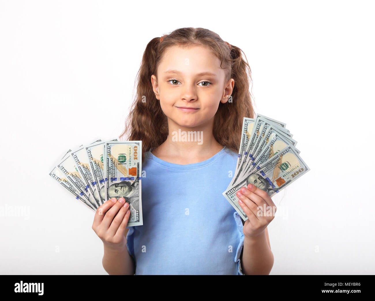Happy smiling rich kid girl holding money in two hands on white ...
