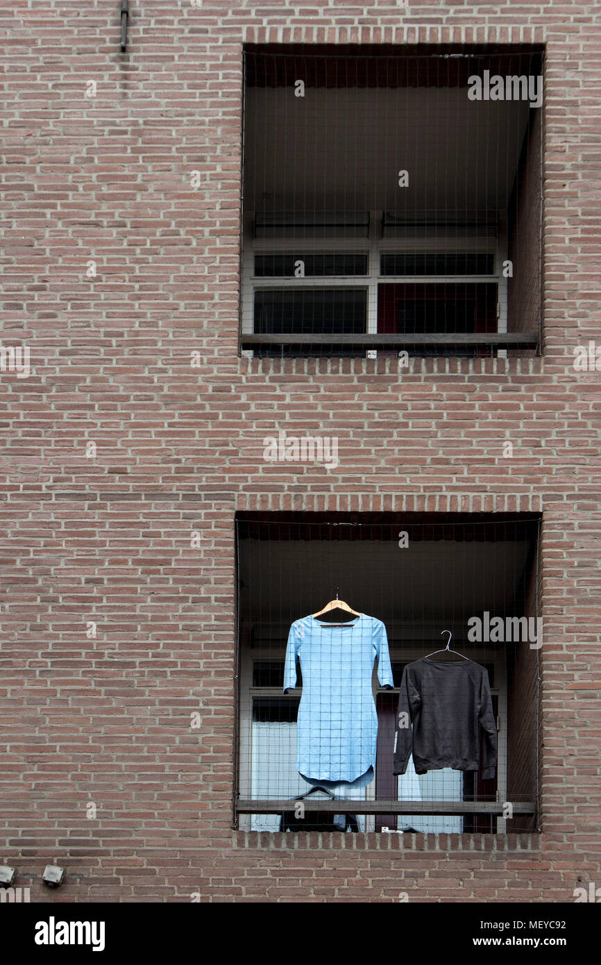Women dress and men jacket dry in the window of a brick house Stock ...