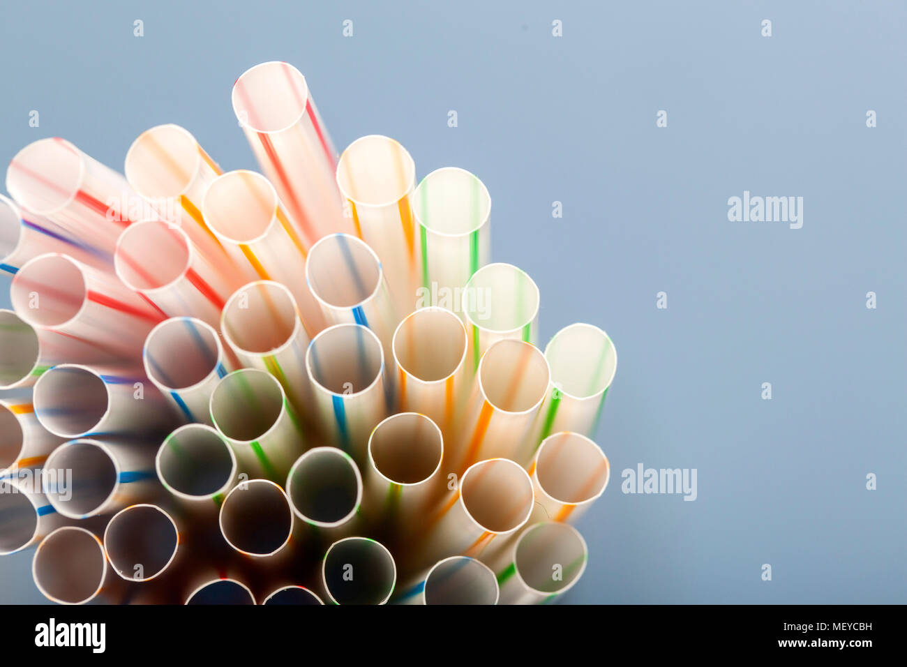 Plastic straws on a blue background Stock Photo - Alamy