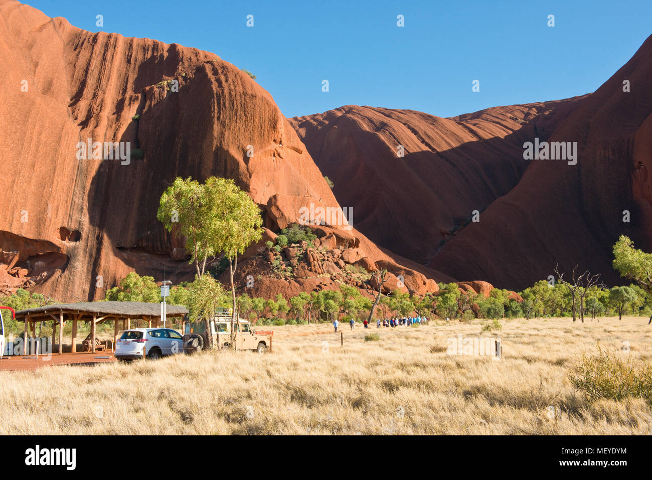 Tourists walking toward the Mutitjulu Waterhole of Uluru (Ayers Rock ...