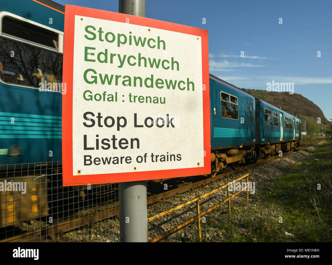 Warning sign on a footpath that crossing a railway line with a commuter ...