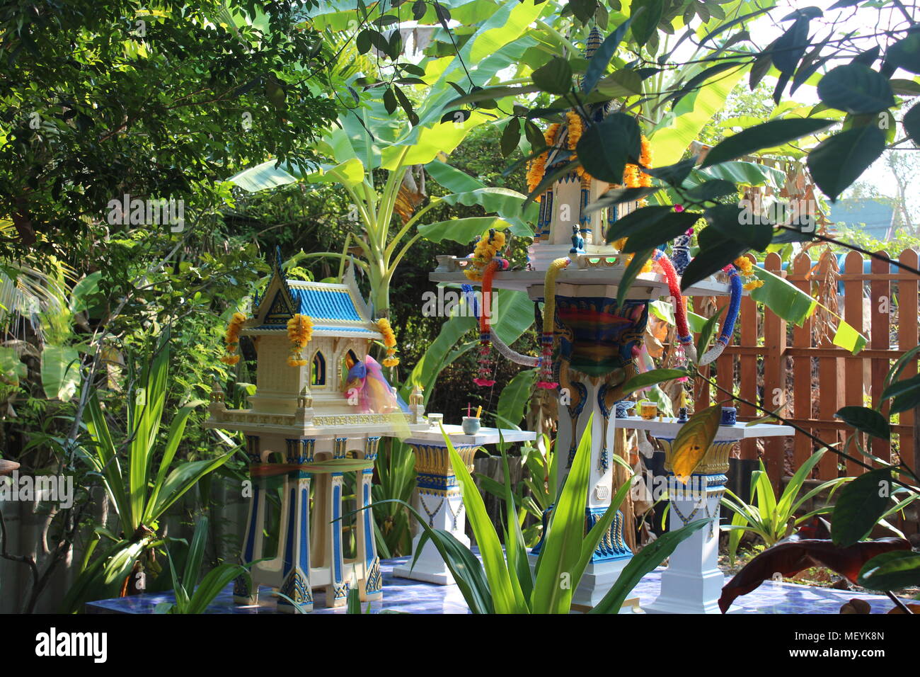 Thai shrine of household God, miniature spirit house in a garden. San ...