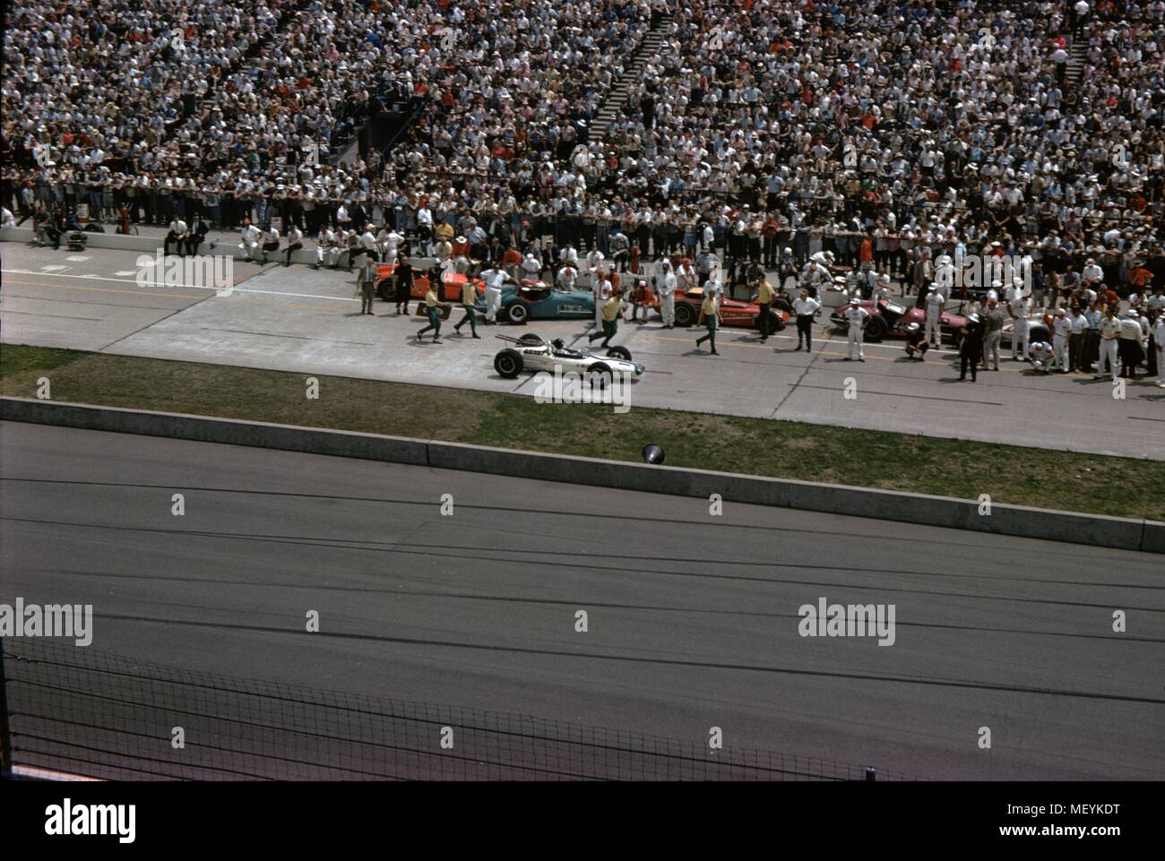 Race cars and spectators are visible at the Indianapolis 500 automobile ...