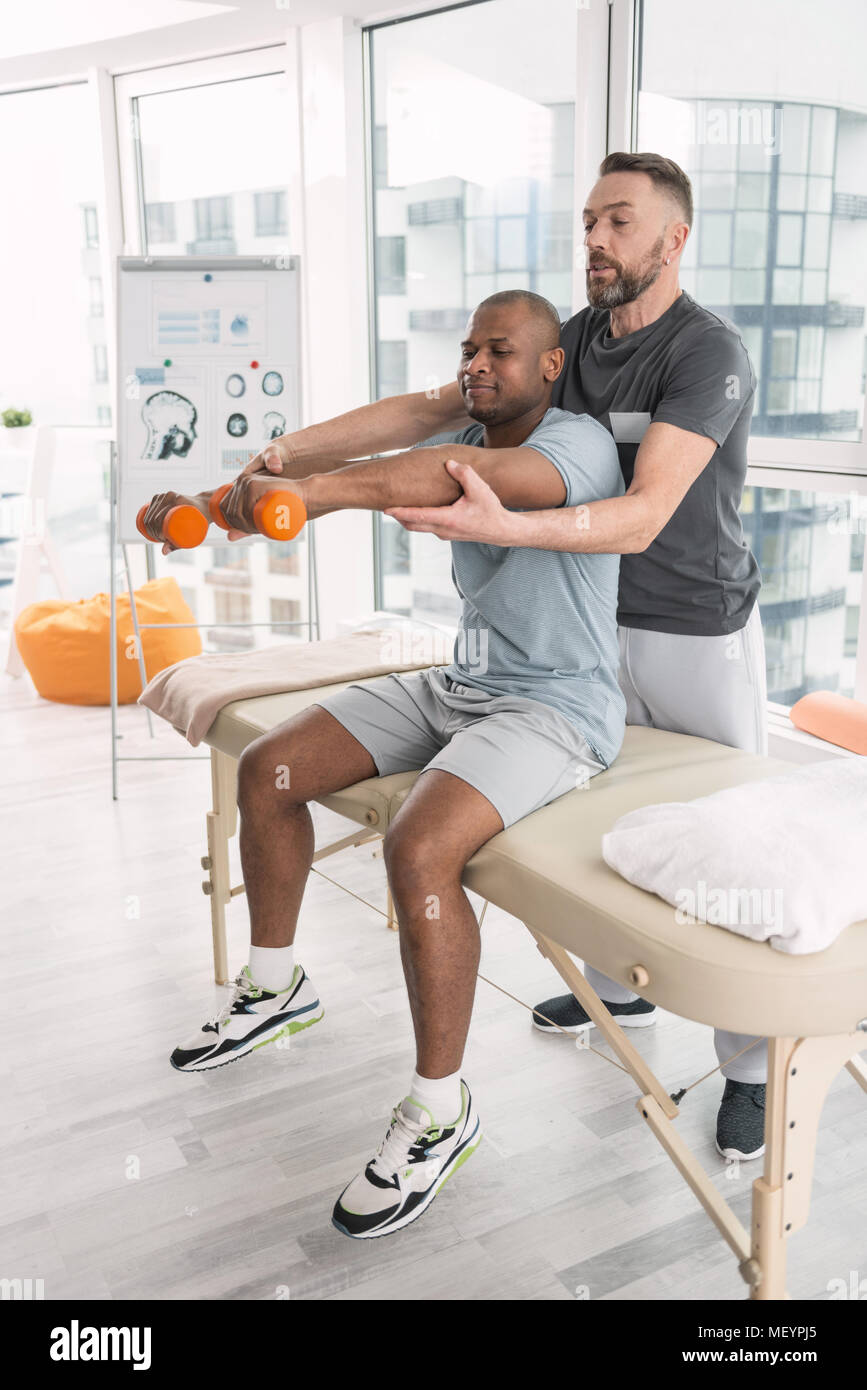 Skillful handsome doctor helping his patient Stock Photo - Alamy