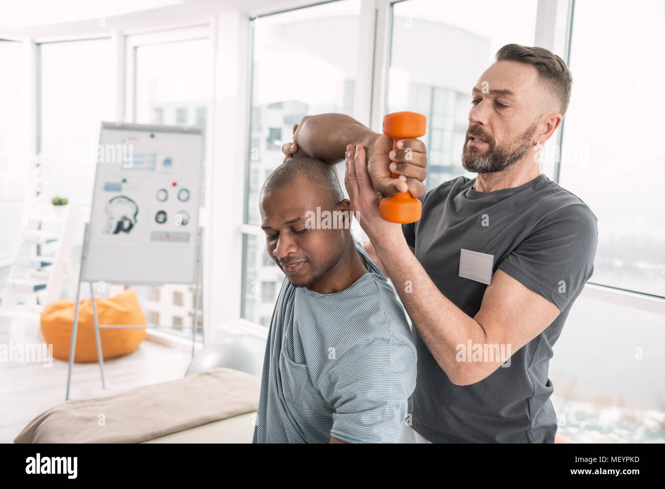Smart young man lifting weights Stock Photo - Alamy