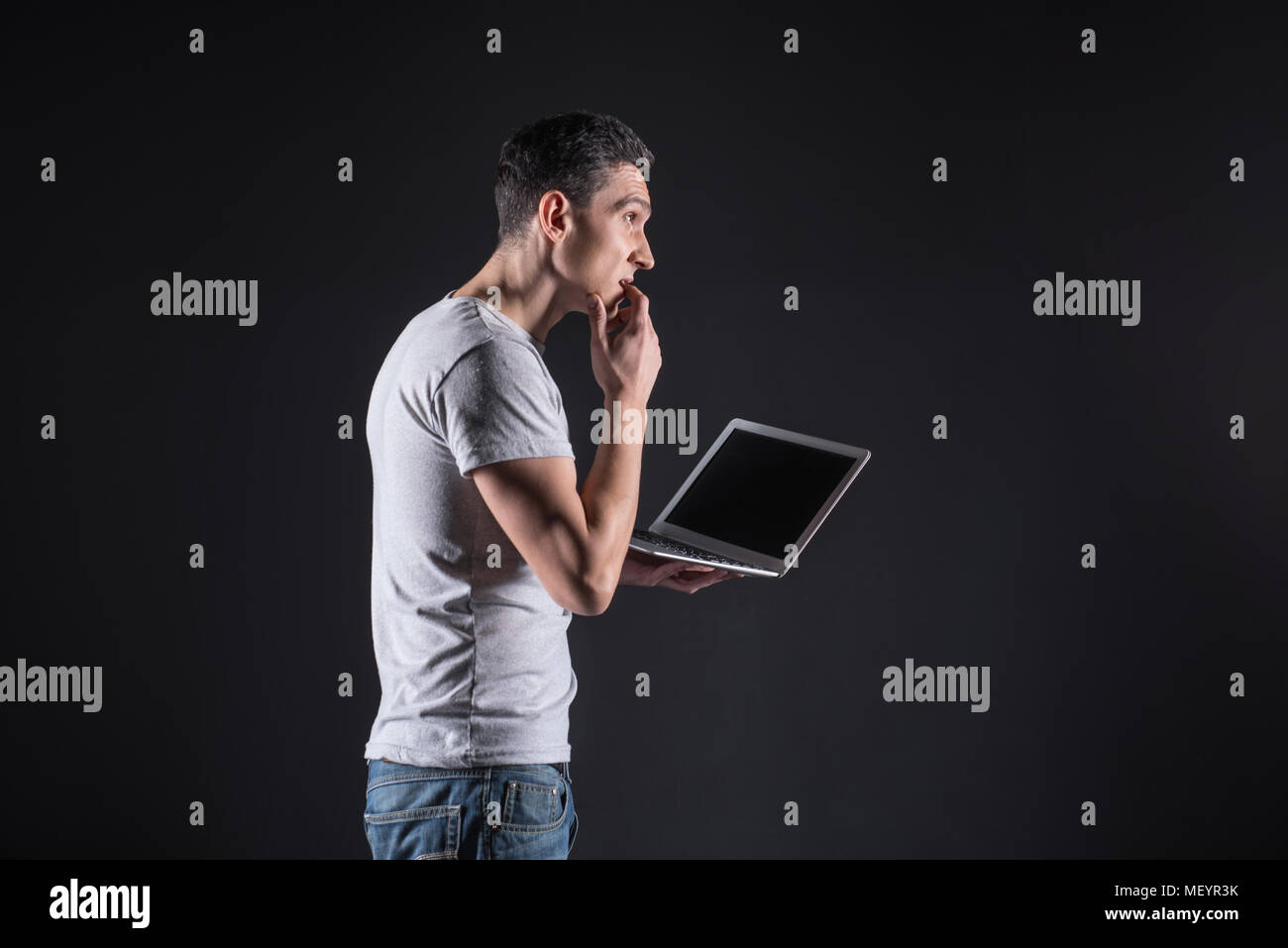 Intelligent thoughtful man biting his finger Stock Photo - Alamy