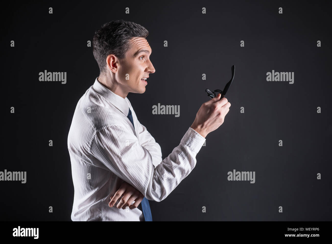 Serious smart man holding his glasses Stock Photo - Alamy