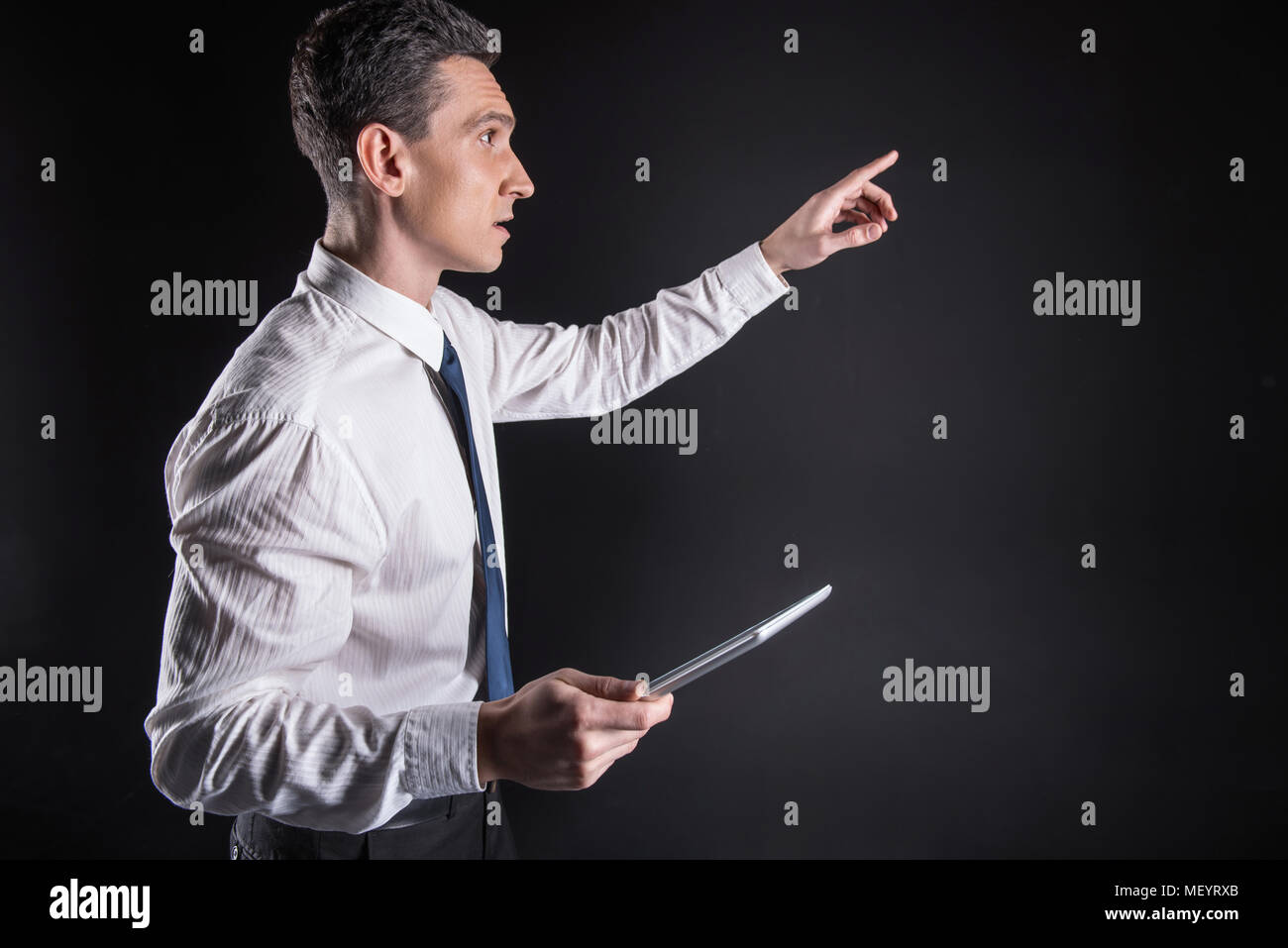 Pleasant adult man pointing at the screen Stock Photo - Alamy