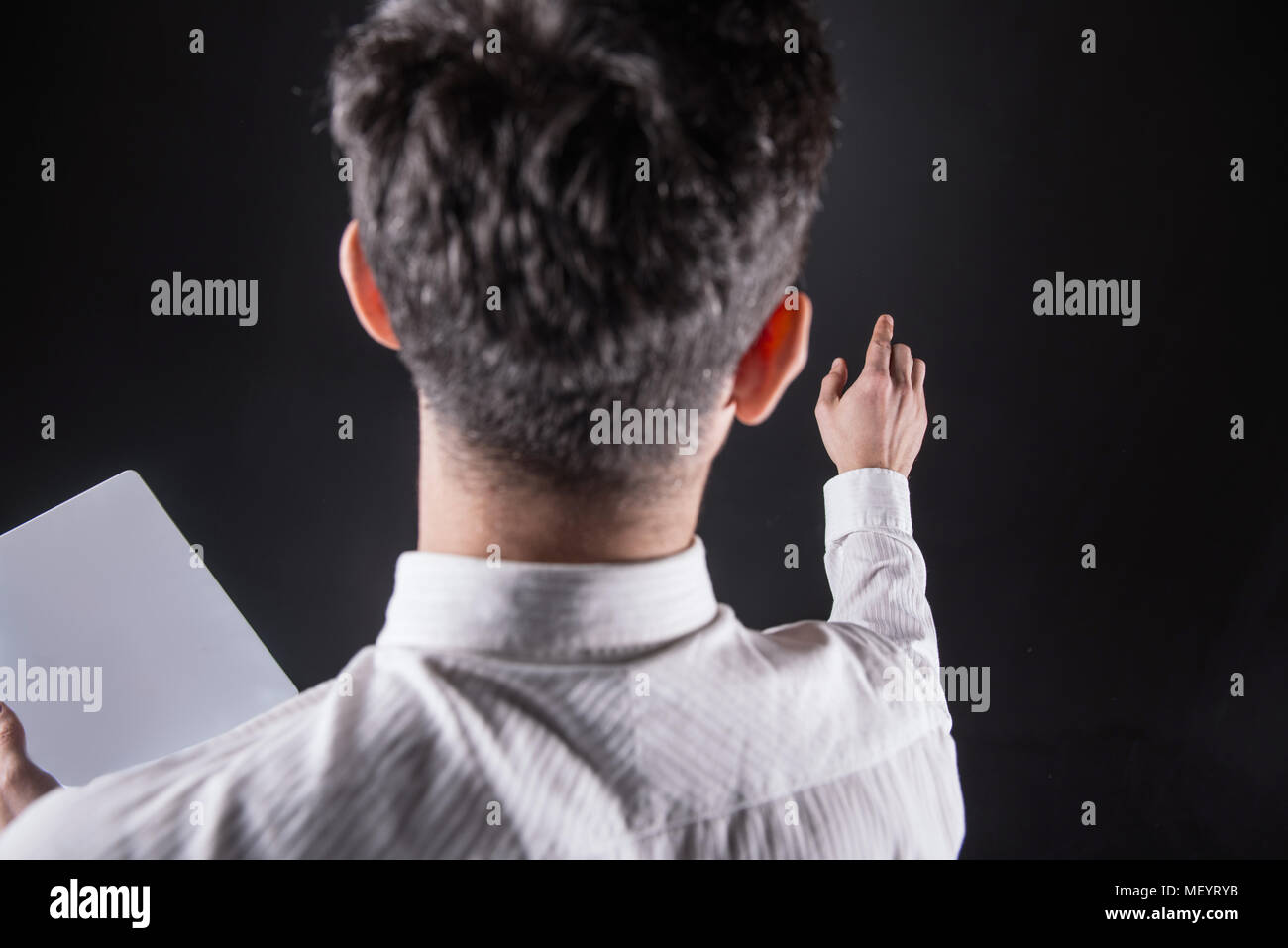 Nice young man looking at his hand Stock Photo - Alamy