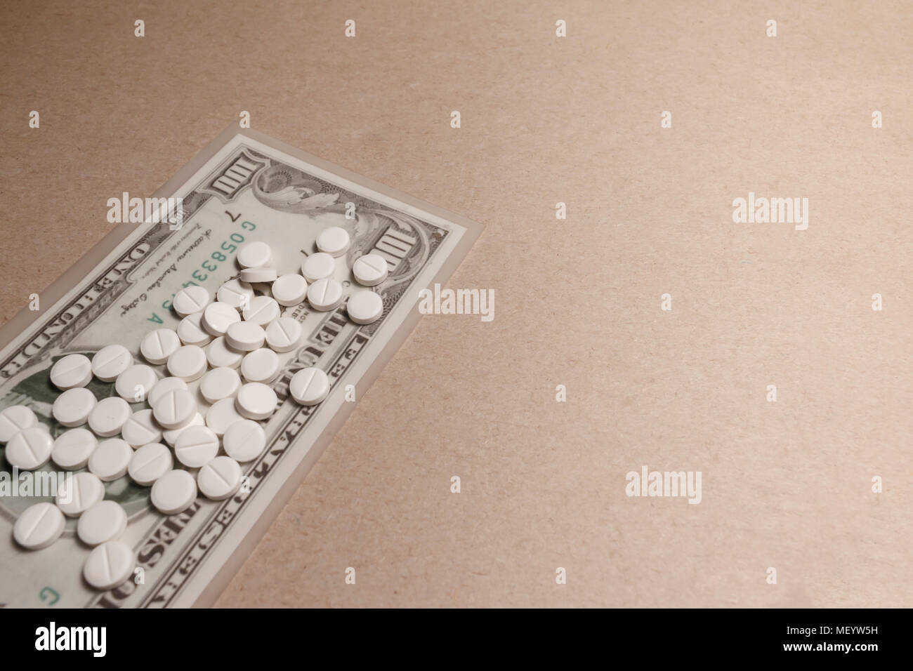 a pile of tablets on one hundred dollar bill on the gray background ...