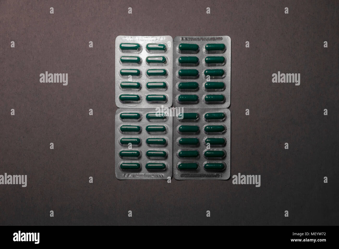 Four blisters of green medicine drugs squared on a cardboard Stock ...