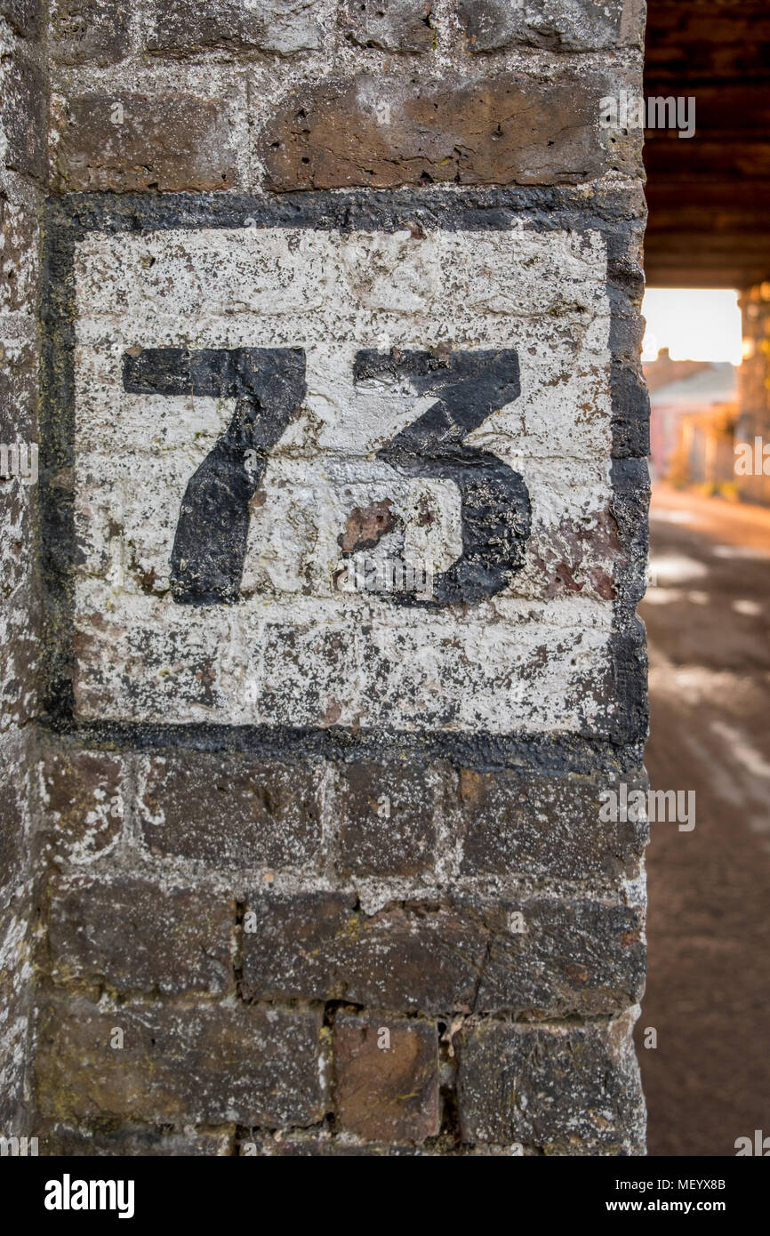 Painted number 73 on old brick wall Stock Photo - Alamy