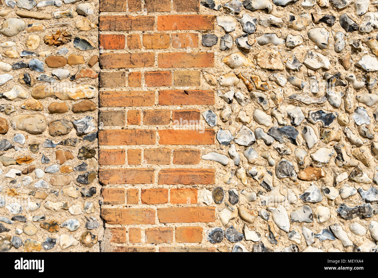 A close up showing the detail of a flint and brick wall on a building ...