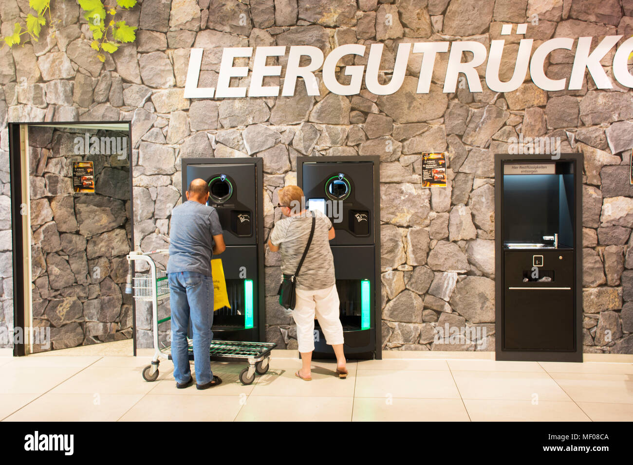 German people put and return empty bottle into Reverse Vending Machine ...