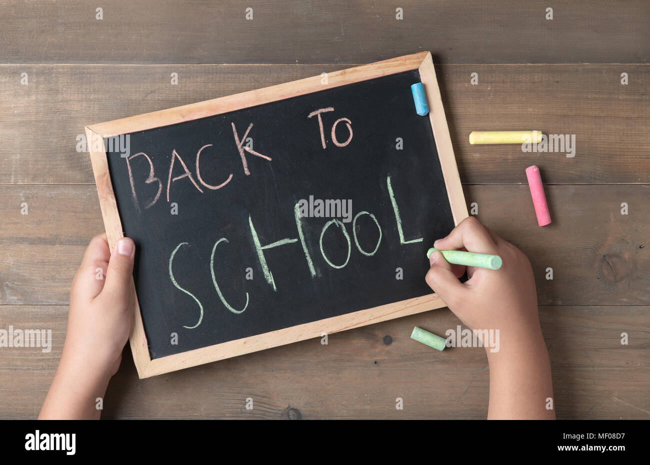 Little hand writing back to school on black chalk board., Back to ...