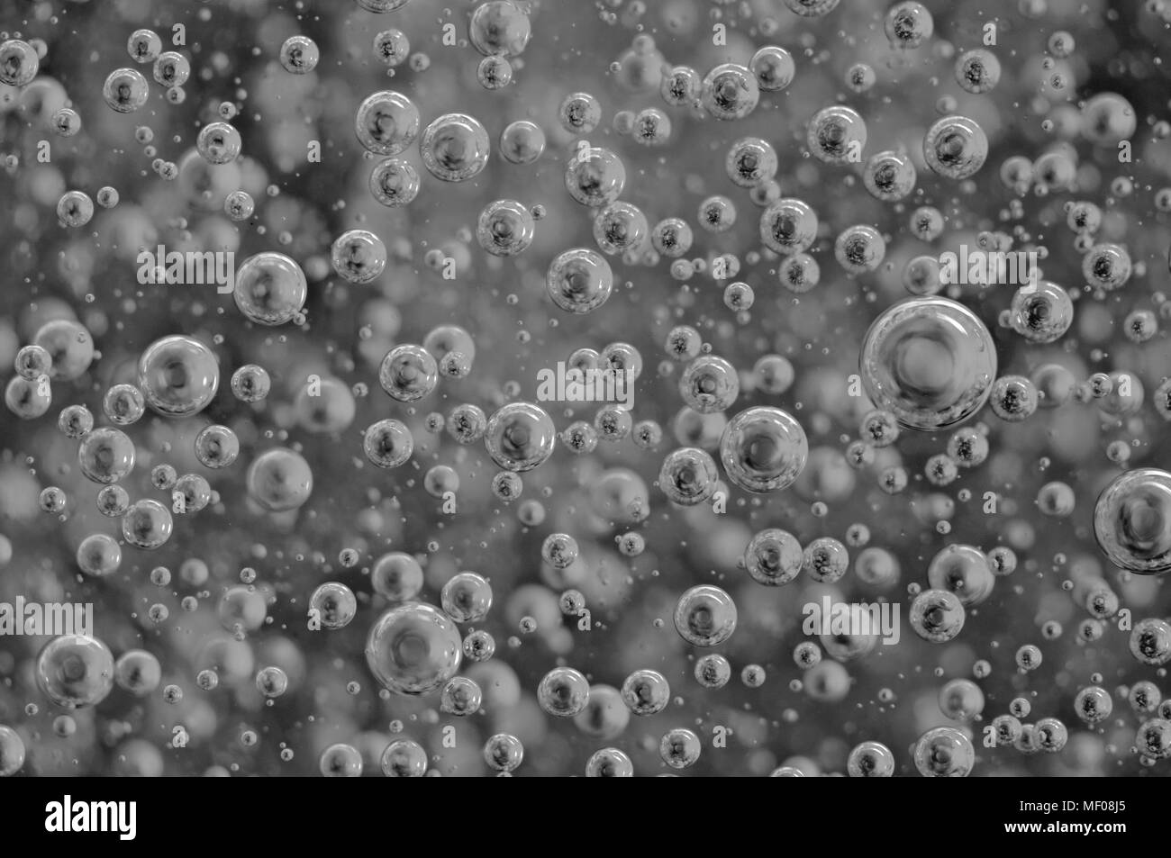 Black-and-white background with big and small grey bubbles inside a ...