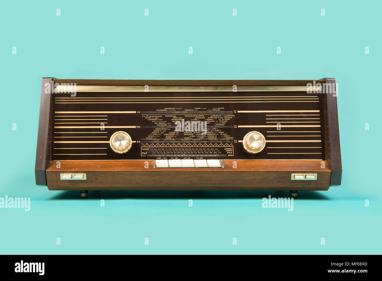 Antique retro radio seen from the front on a turquoise blue background ...