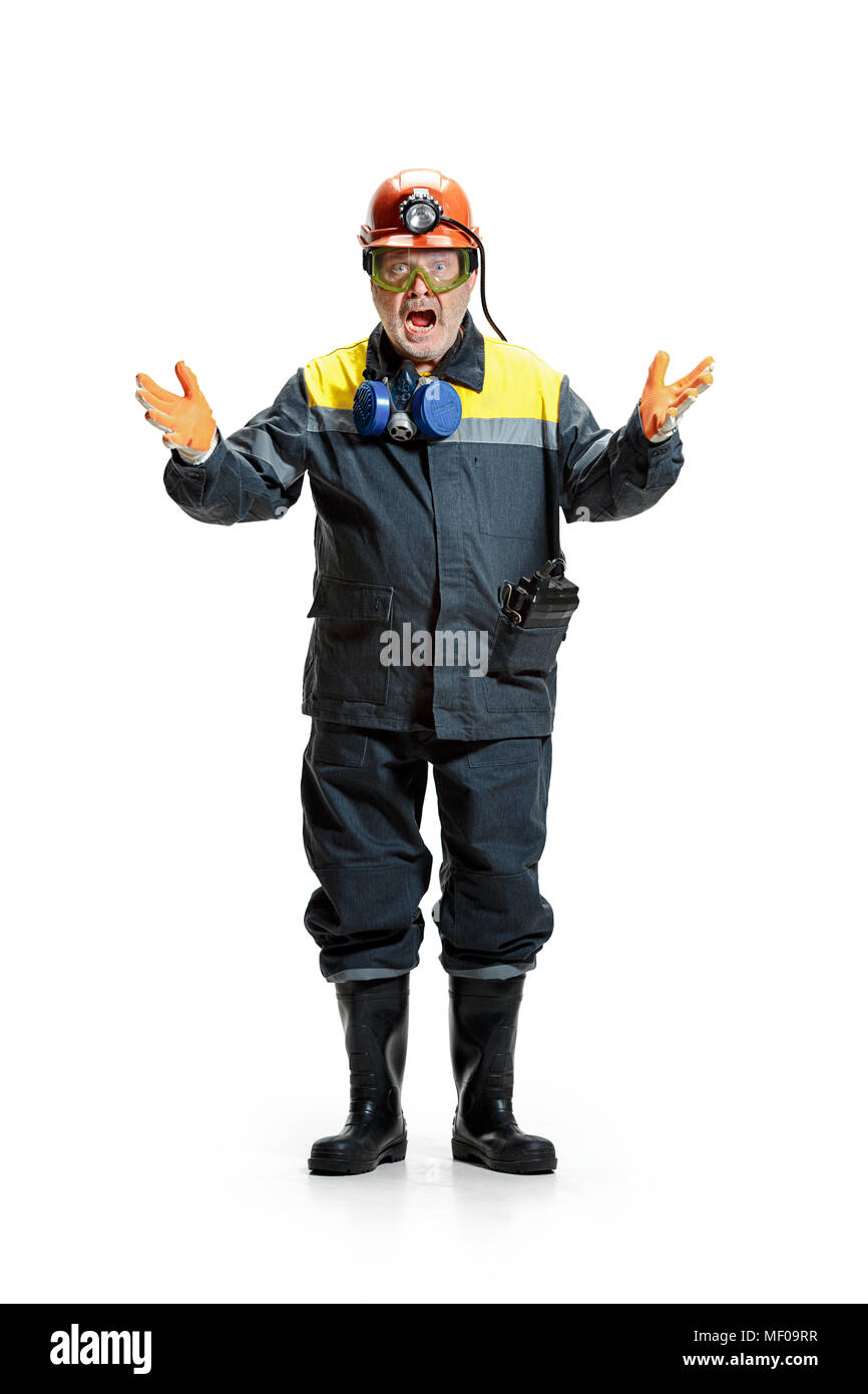 The studio shot of senior bearded male miner standing at the camera on ...