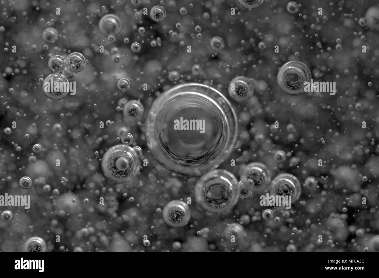 Black-and-white background with big and small grey bubbles inside a ...