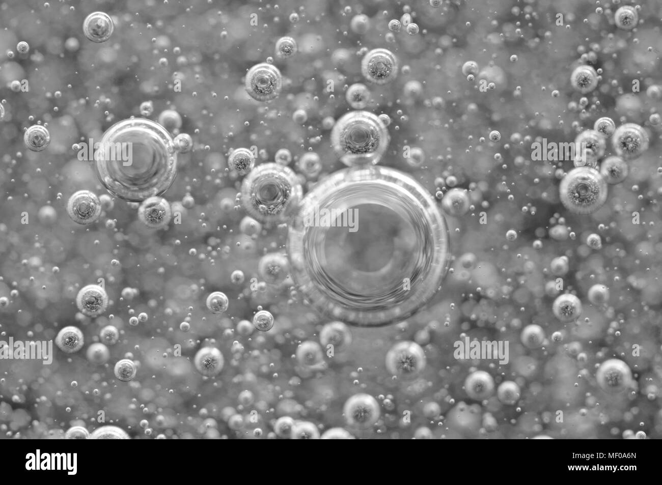 Black-and-white background with big and small grey bubbles inside a ...