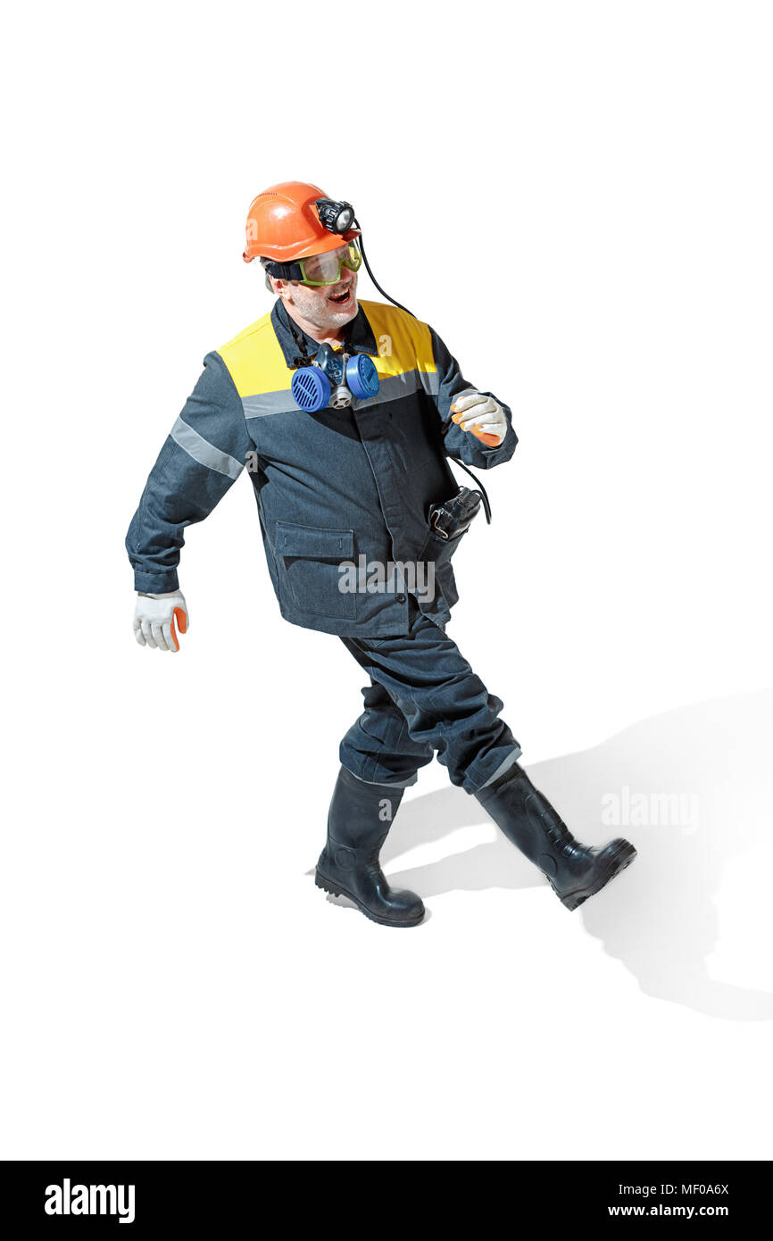 The studio shot of senior bearded male miner standing at the camera on ...