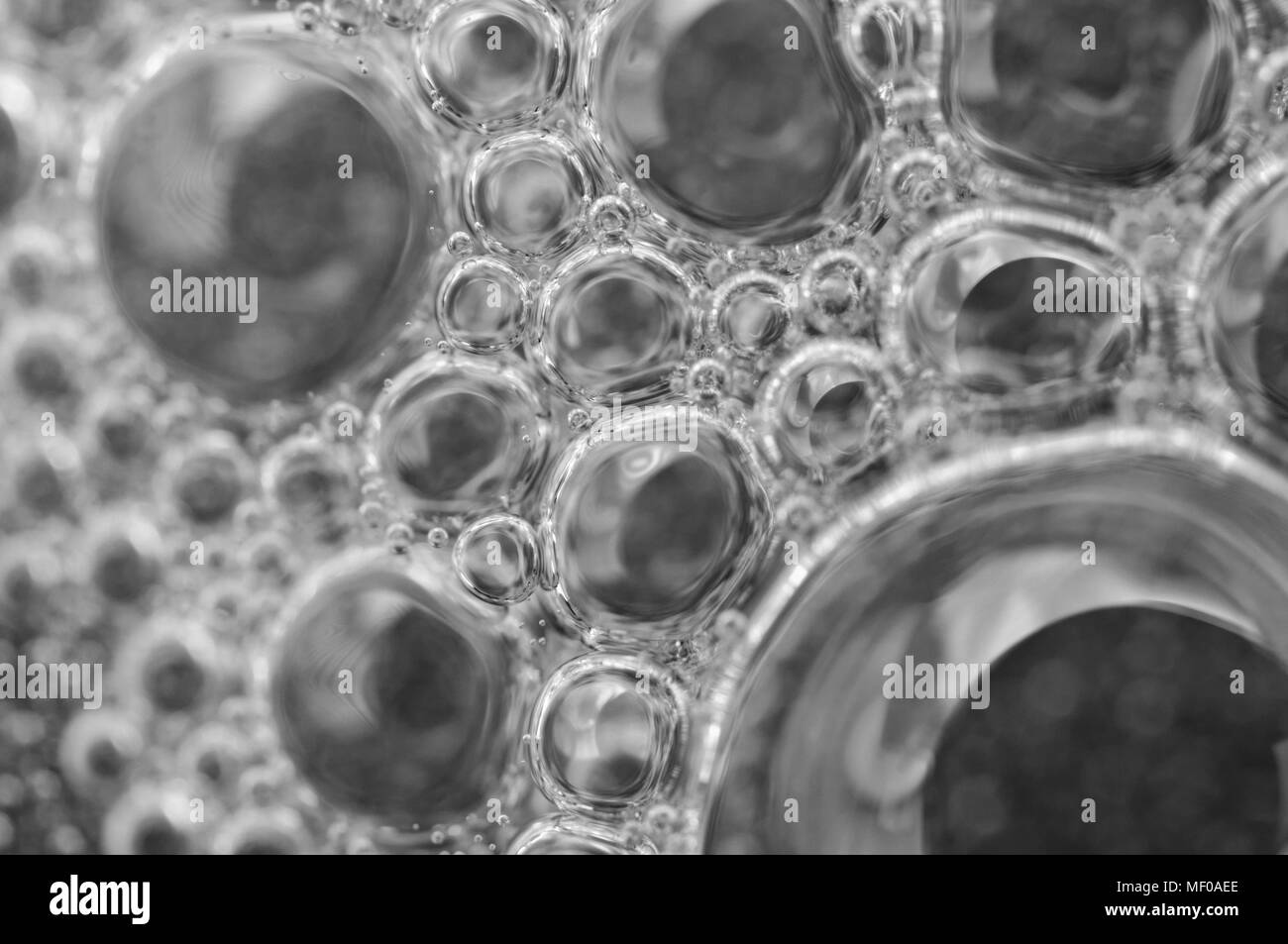 Black-and-white background with big and small grey bubbles inside a ...