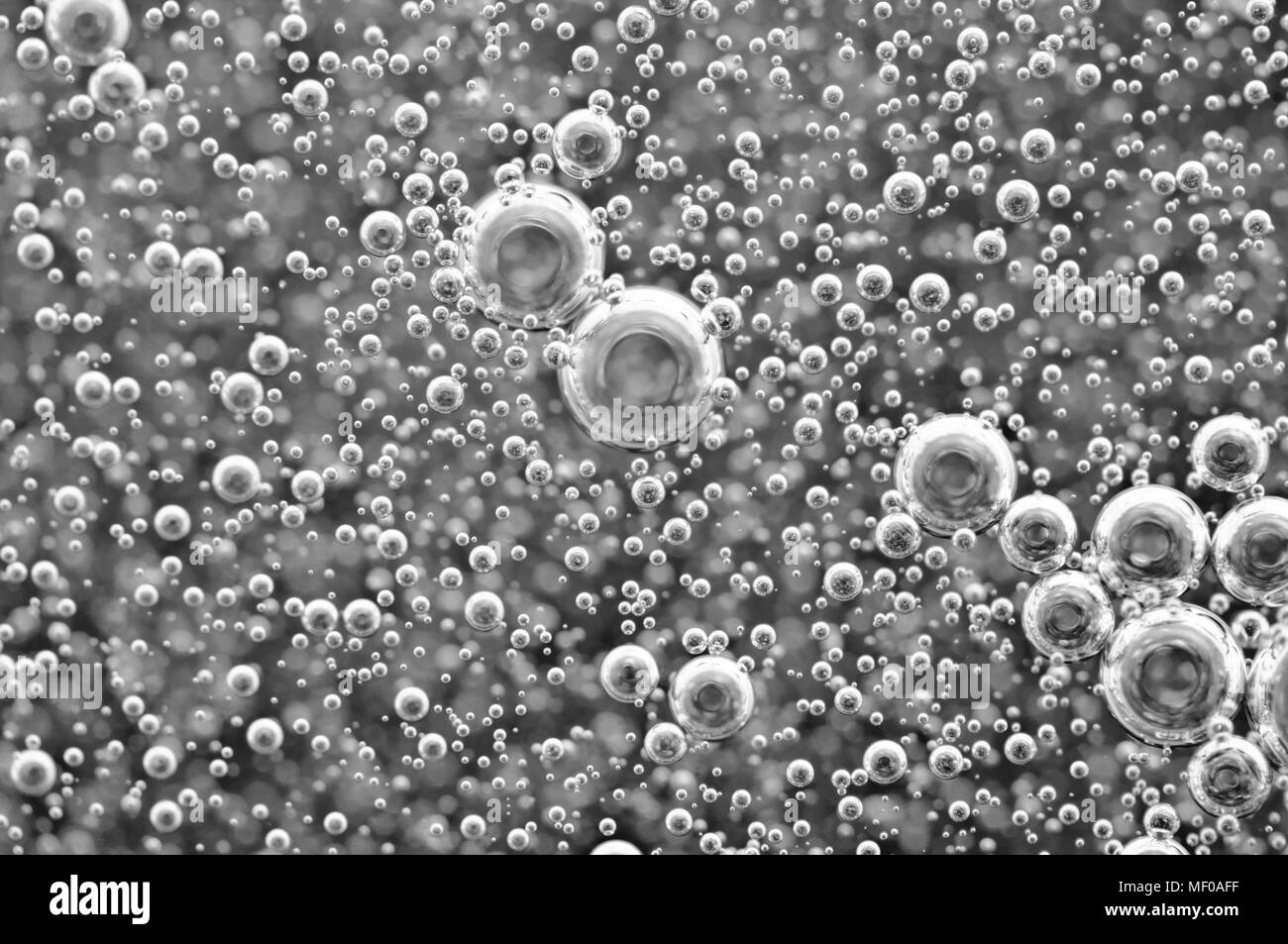Black-and-white background with big and small grey bubbles inside a ...