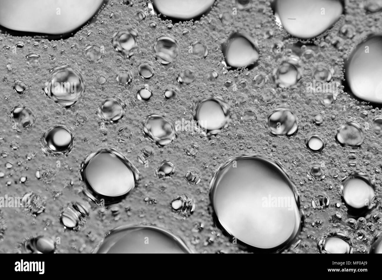 Black-and-white background with big and small grey bubbles inside a ...