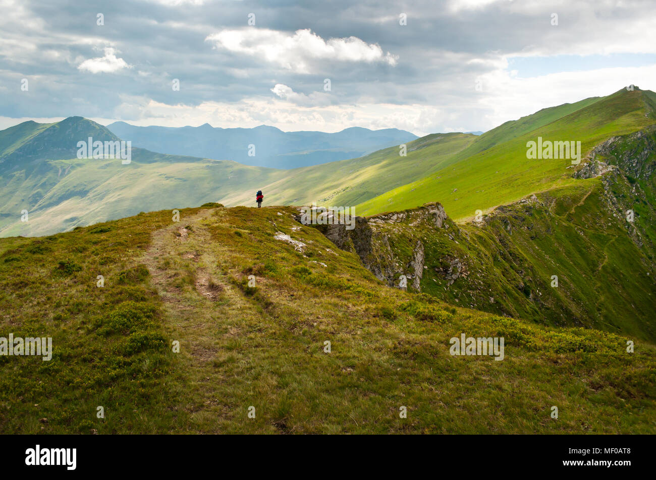 Hiker walking on ridge path Stock Photo - Alamy