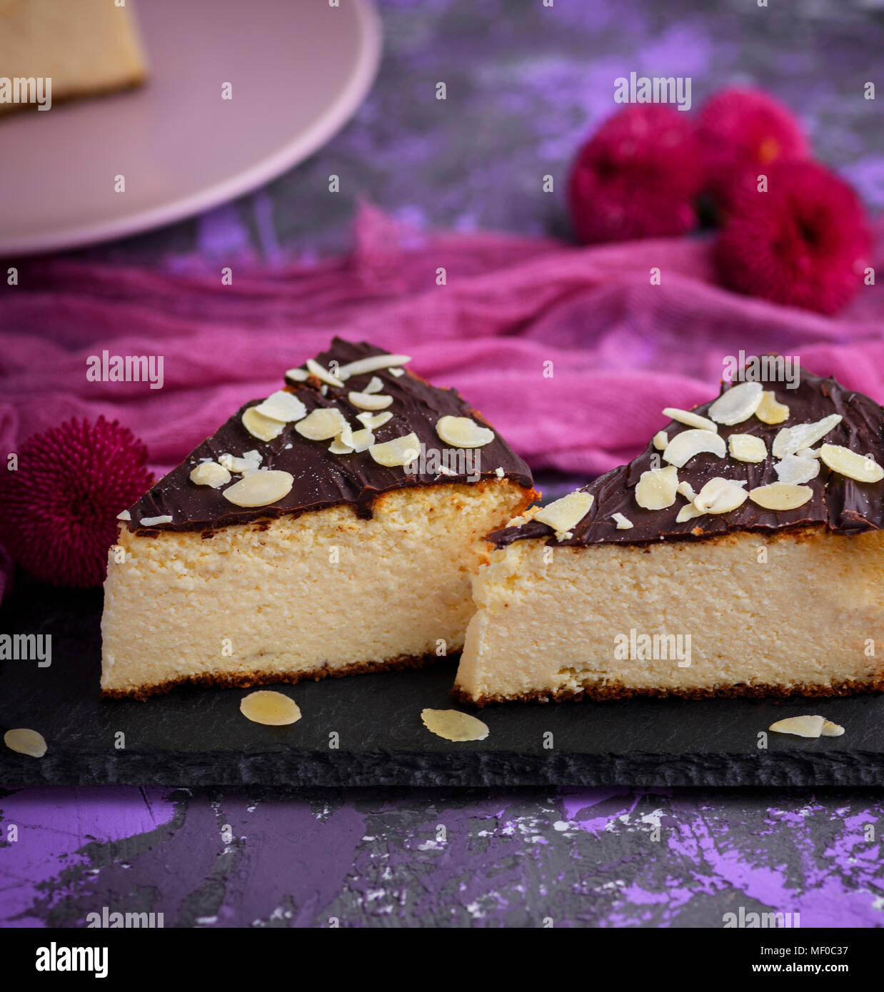 pieces of cheesecake with chocolate on a black graphite plate, close up ...