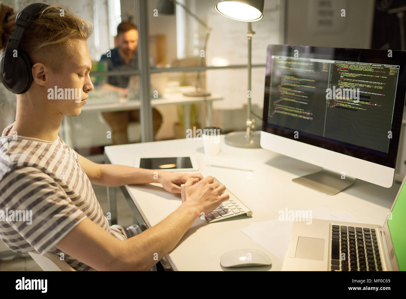 Confident software writer busy with new program Stock Photo - Alamy