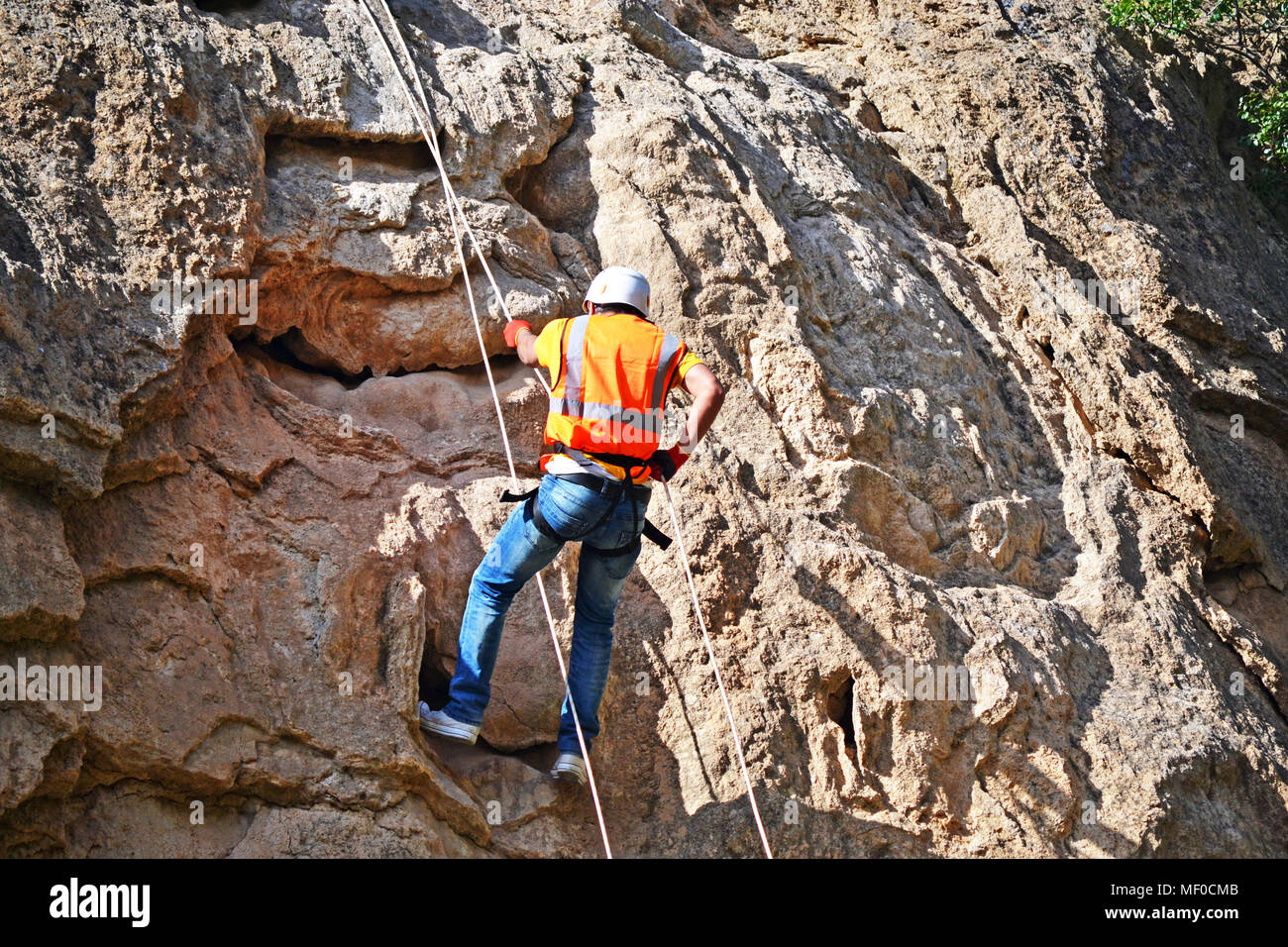 An adventurer falling by rope from the top of a mountain Stock Photo ...