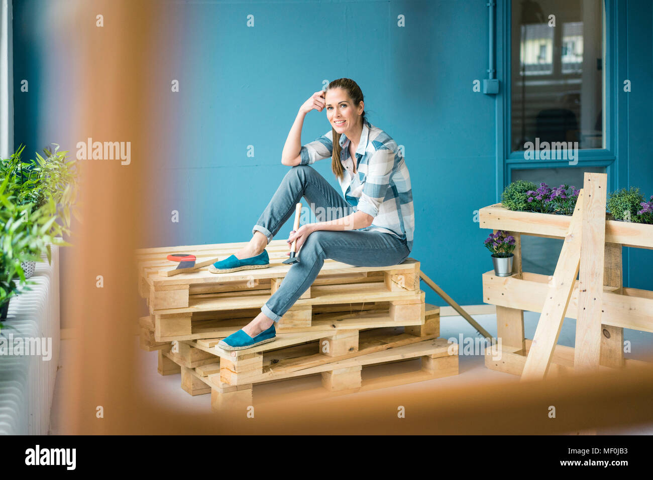 Beautiful woman refurbishing her home with pallets Stock Photo - Alamy
