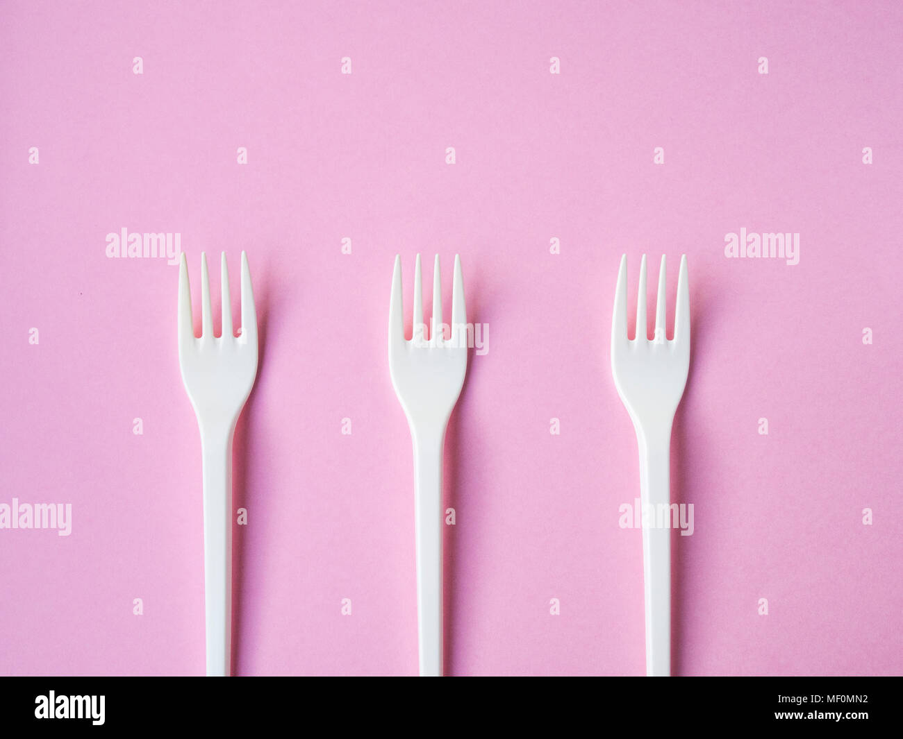 Plastic fork pattern on pink background Stock Photo - Alamy