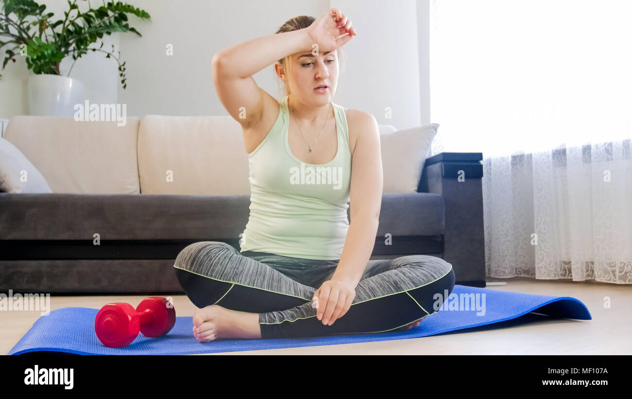 Young tired woman after exercising wiping sweat from her forehead Stock ...
