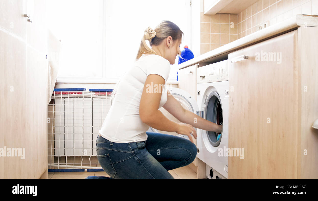 Young housewife loading clothes in washing machine Stock Photo - Alamy