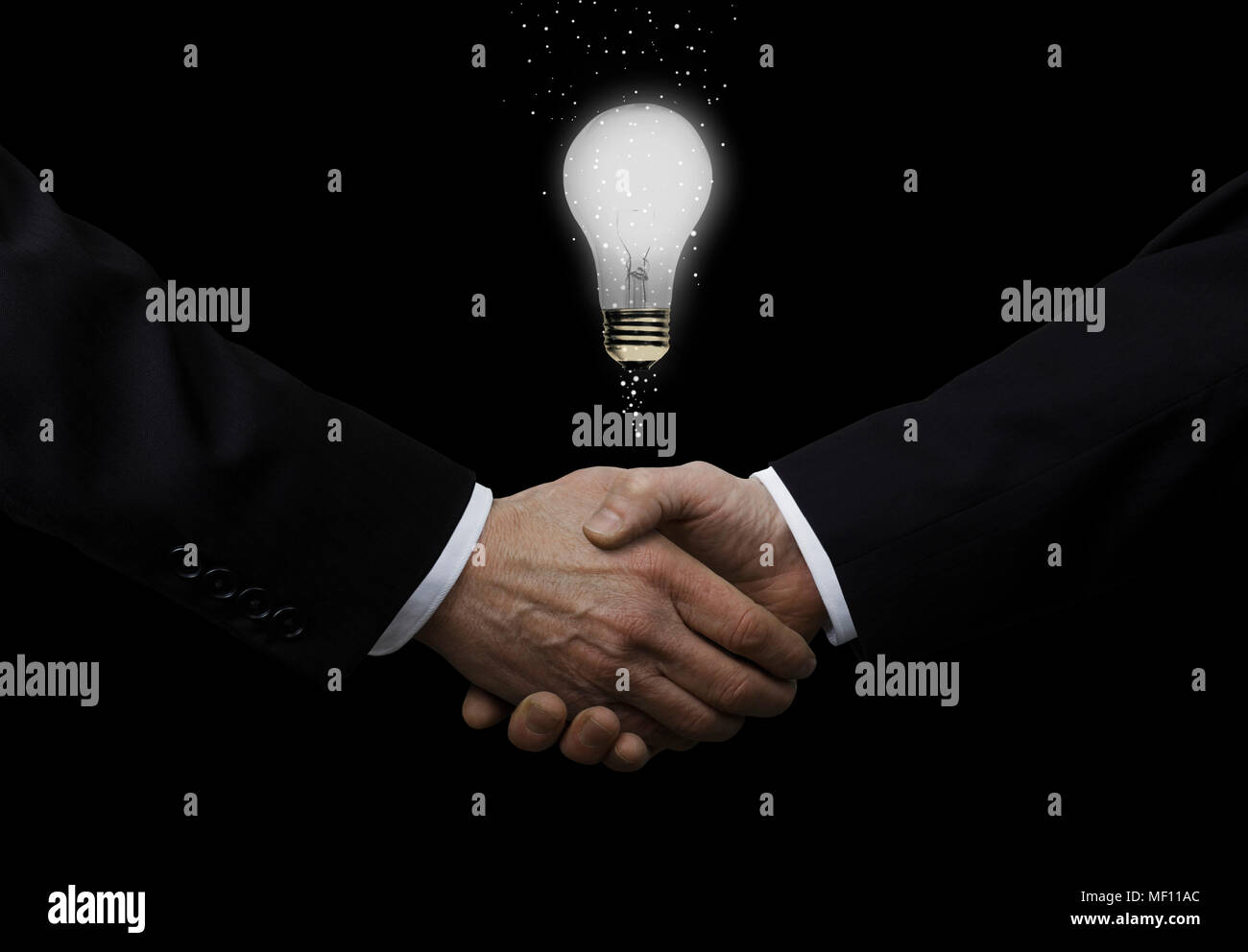 Businessmen Shaking Hands With Light Bulb Stock Photo - Alamy
