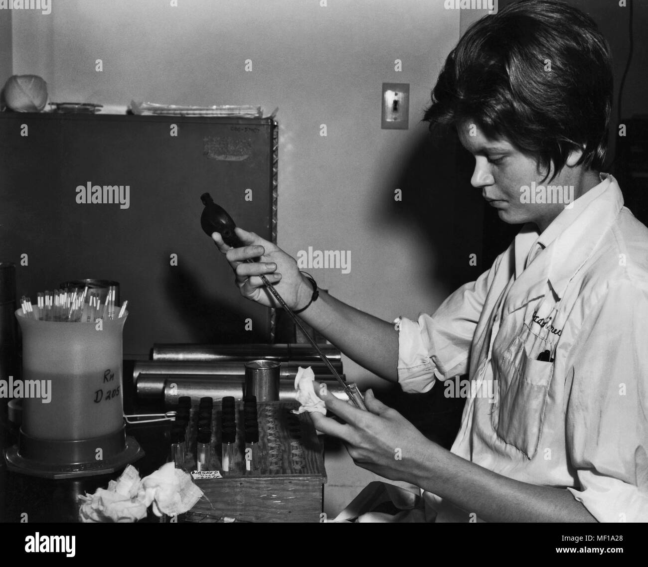 Centers for Disease Control (CDC) laboratorian measuring specimen in a ...