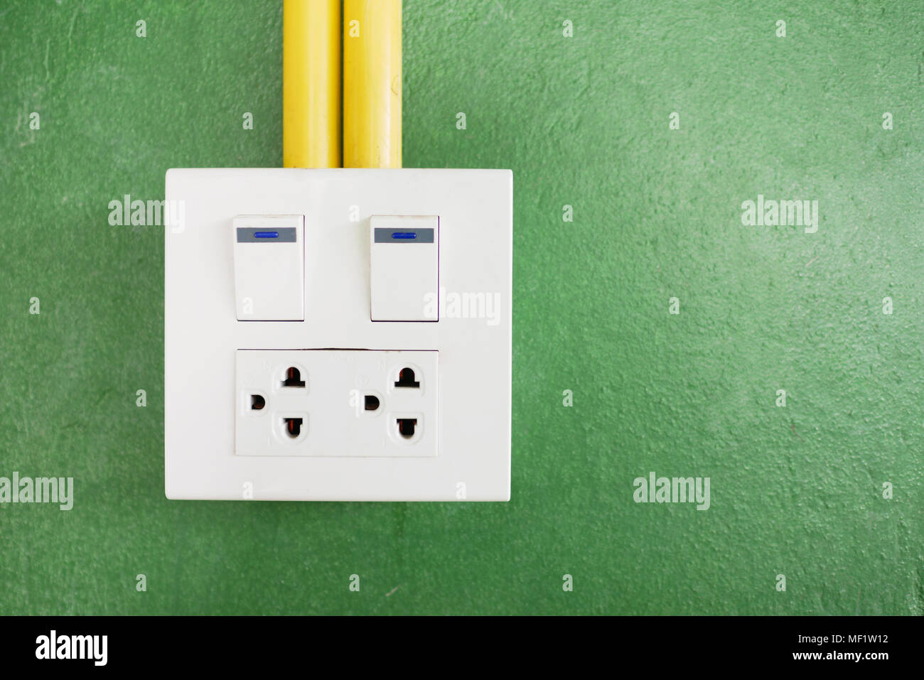Plug and socket on wall as green background Stock Photo - Alamy