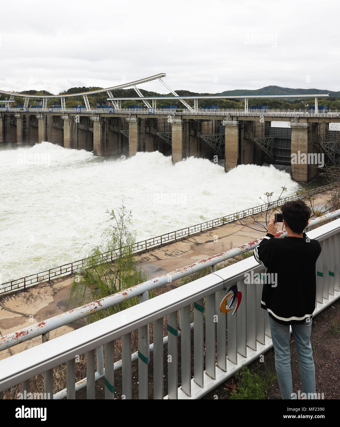 24th Apr, 2018. Dam opens floodgates A man photographs water pouring ...