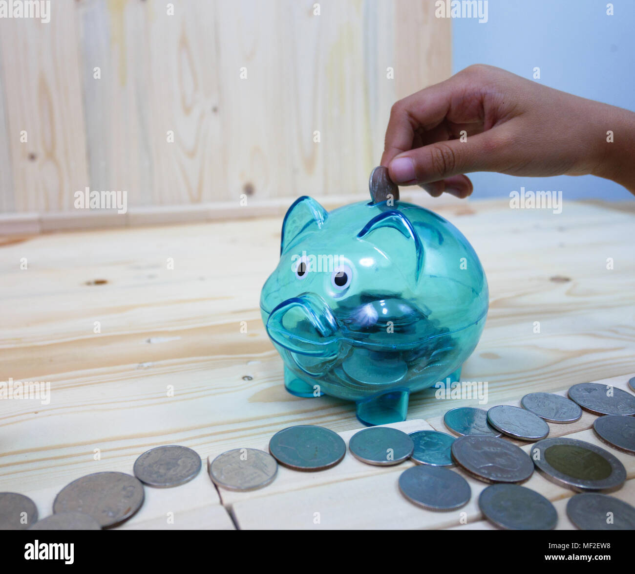 hand girl drop coin in piggy bank Stock Photo - Alamy