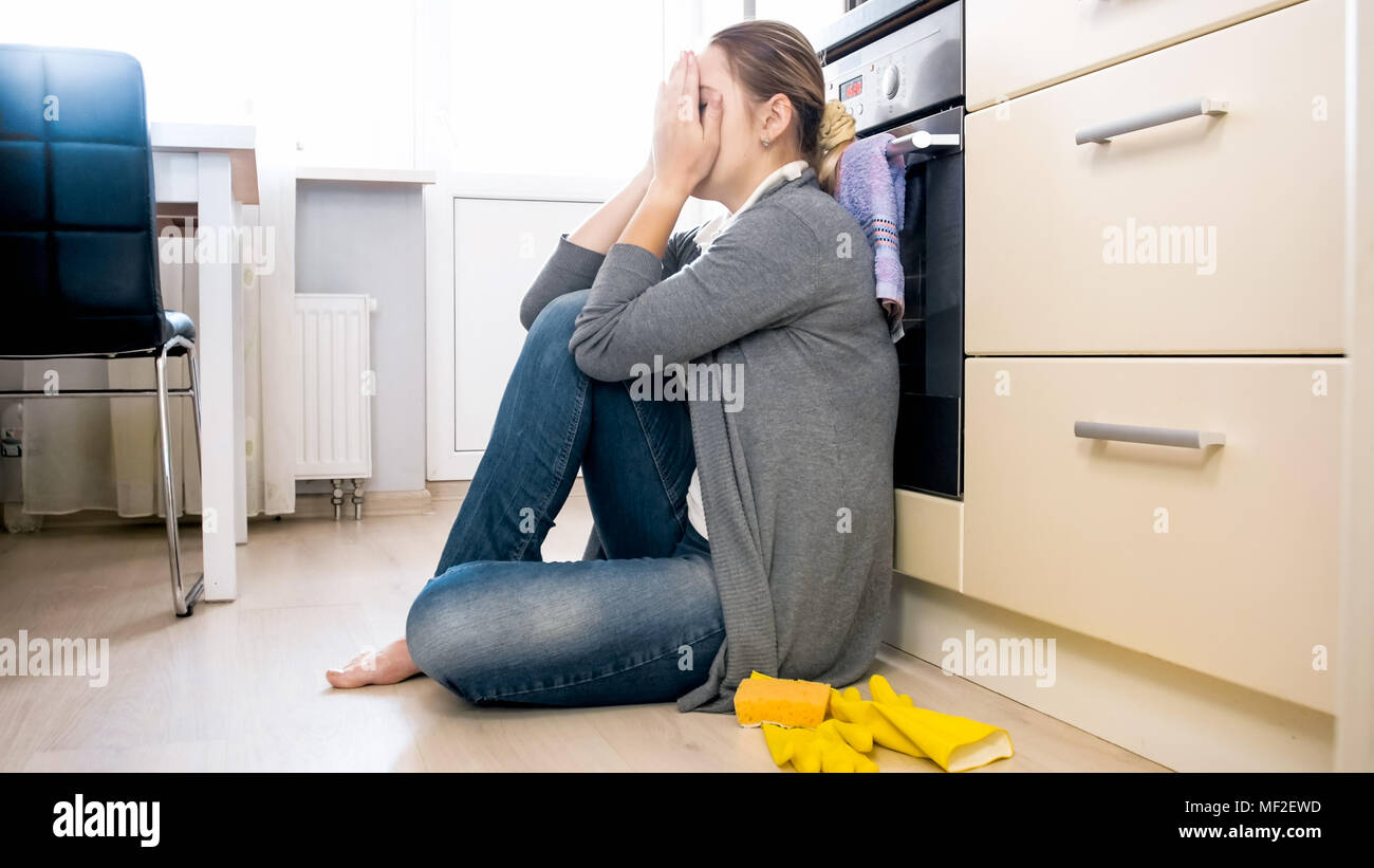 Young tired housewife crying on floor and closing face with hands Stock ...