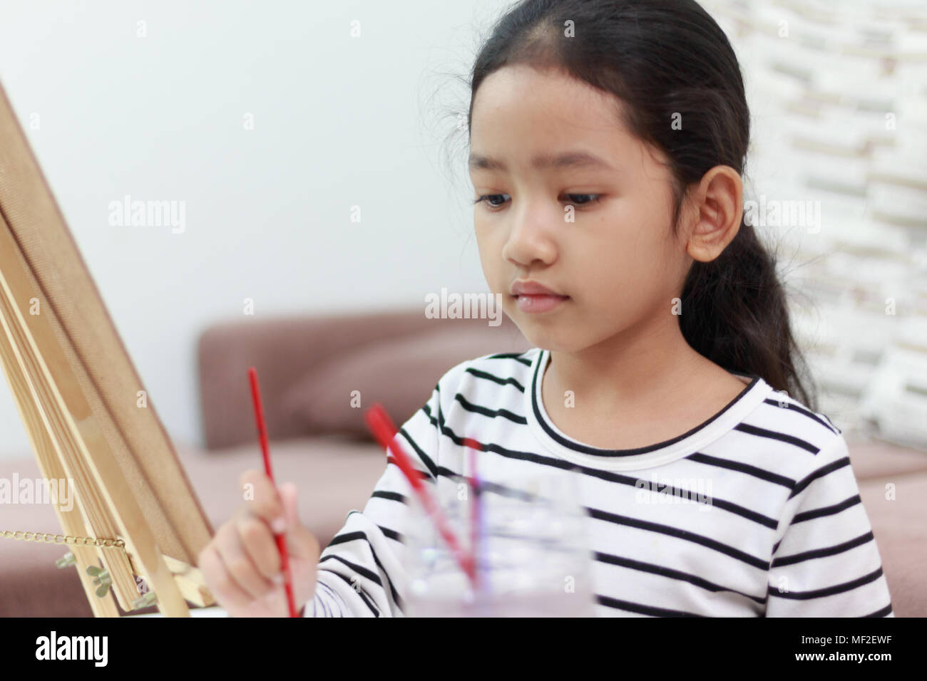 hand girl holding a red paintbrush draws picture at home Stock Photo ...