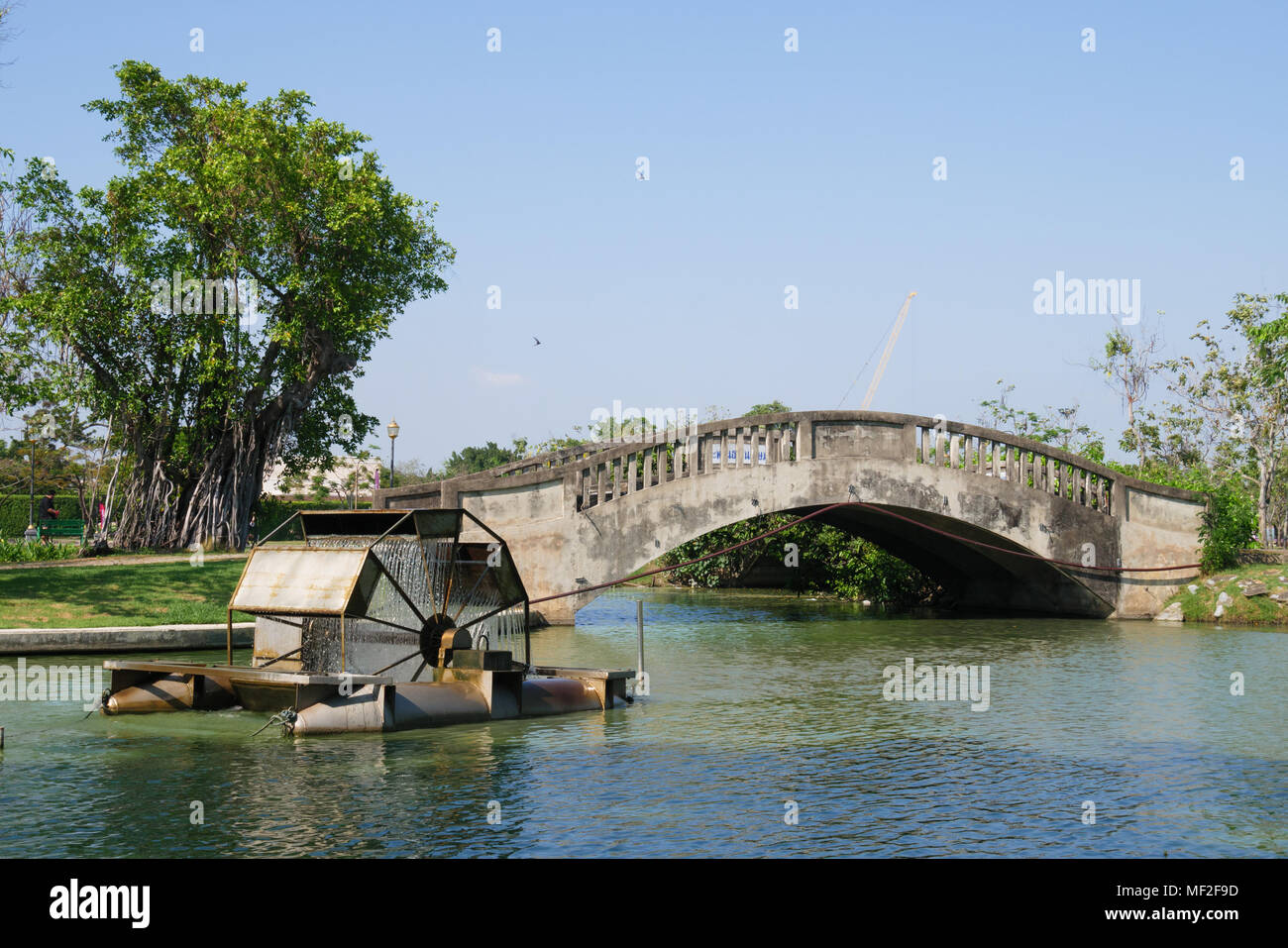 Turbine Rotating Water, Bridge and Tree in park Stock Photo - Alamy