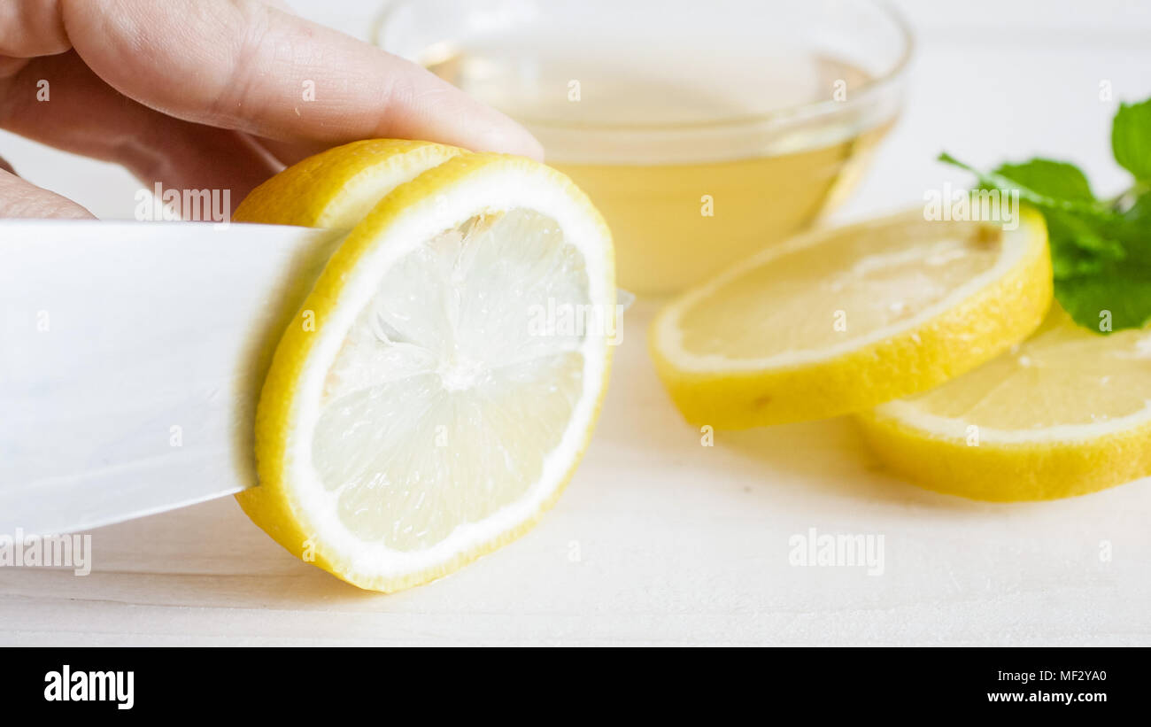 Closeup photo of cutting fresh lemon with sharp knife Stock Photo - Alamy