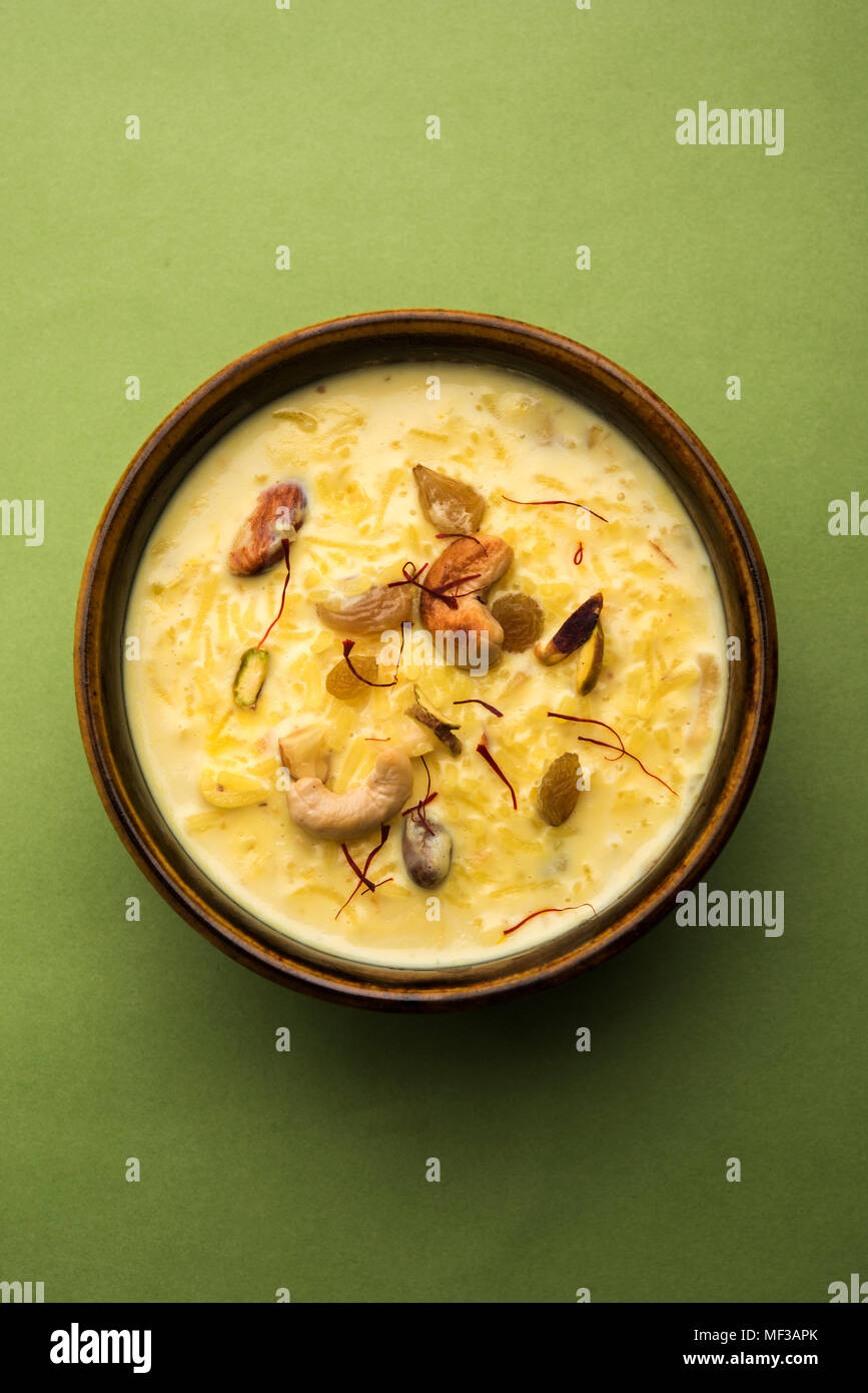 kheer or rice pudding is an Indian dessert in a brown terracotta bowl ...