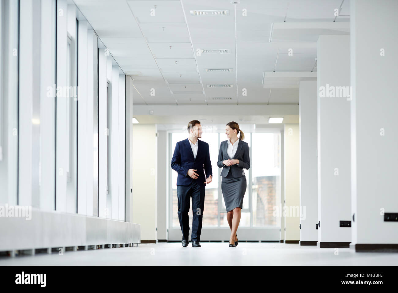 Two colleagues walking office corridor hi-res stock photography and ...